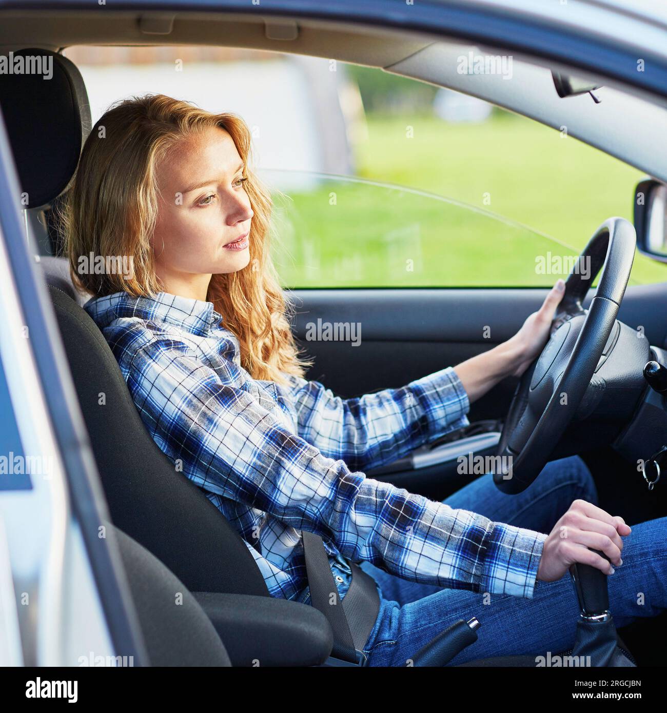 Beautiful young confident woman driving a car Stock Photo - Alamy