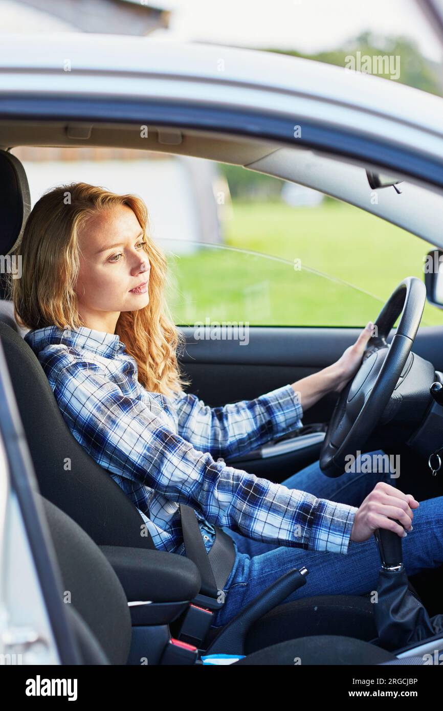 Beautiful young confident woman driving a car Stock Photo - Alamy