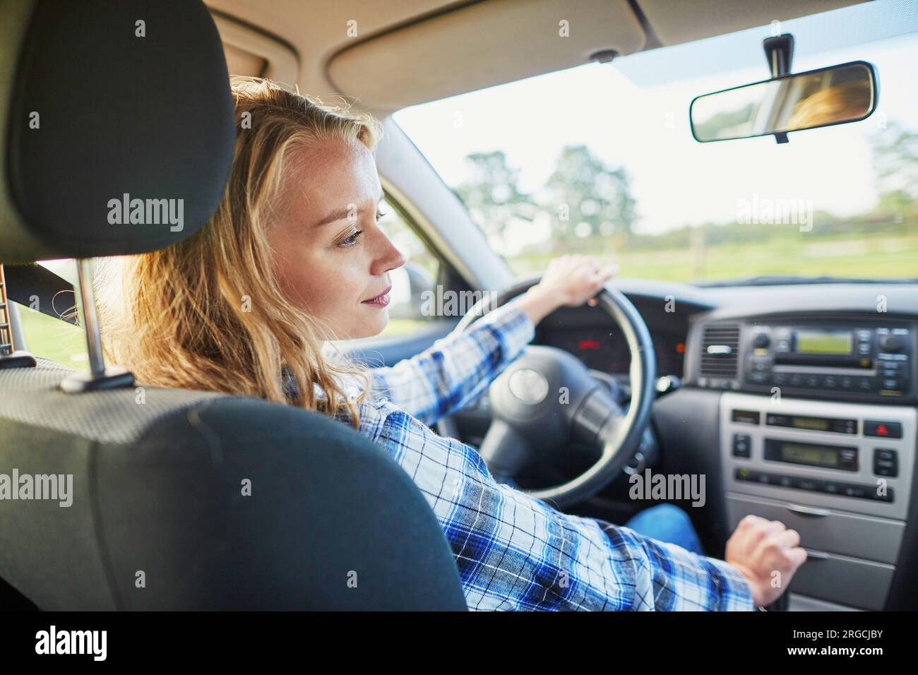 Beautiful young confident woman driving a car Stock Photo - Alamy
