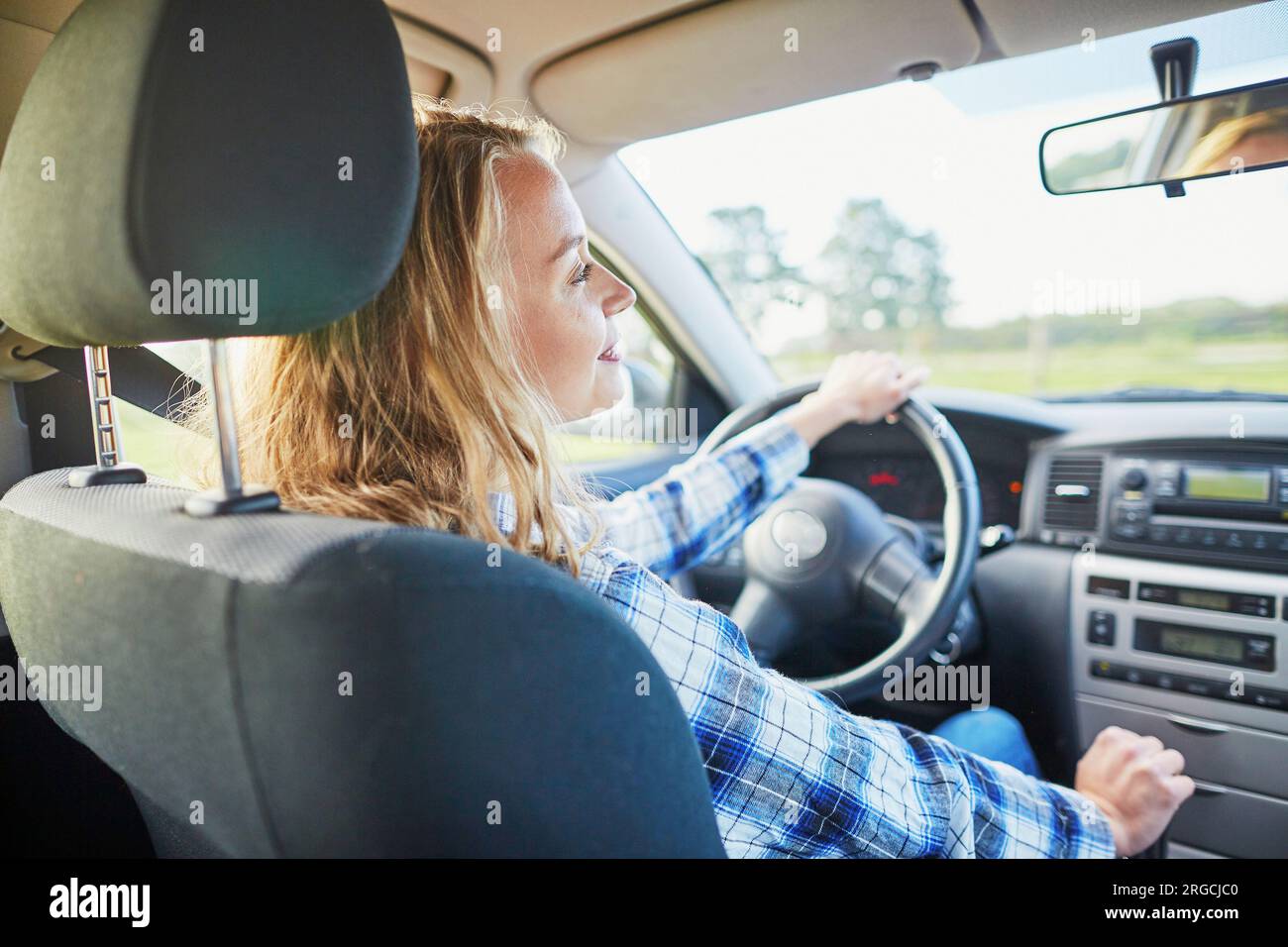 Beautiful young confident woman driving a car Stock Photo - Alamy