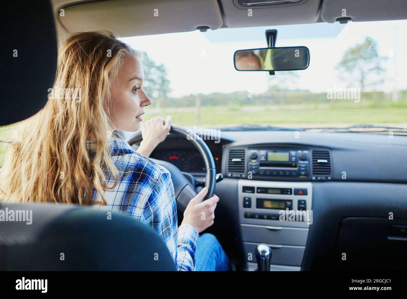 Beautiful young confident woman driving a car Stock Photo - Alamy