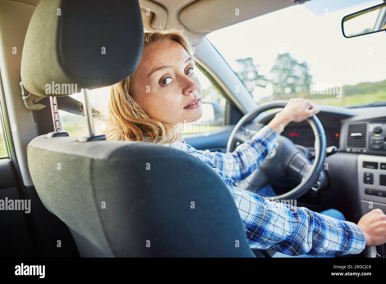 Beautiful young confident woman driving a car Stock Photo - Alamy