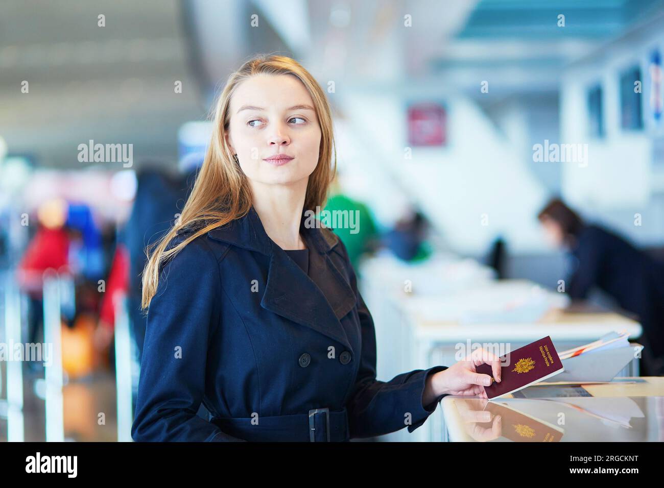 Young woman in international airport at check-in counter, giving her ...