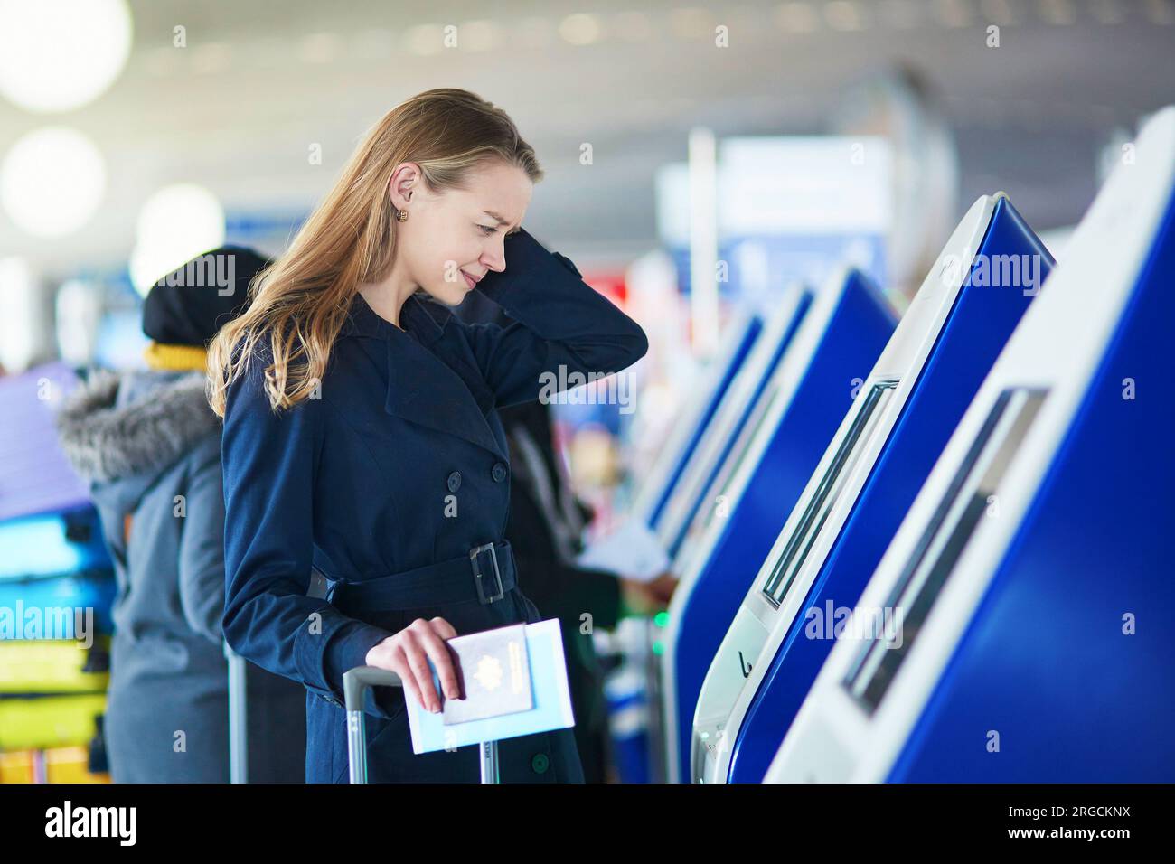 Young woman in international airport doing self check-in, stressed and ...