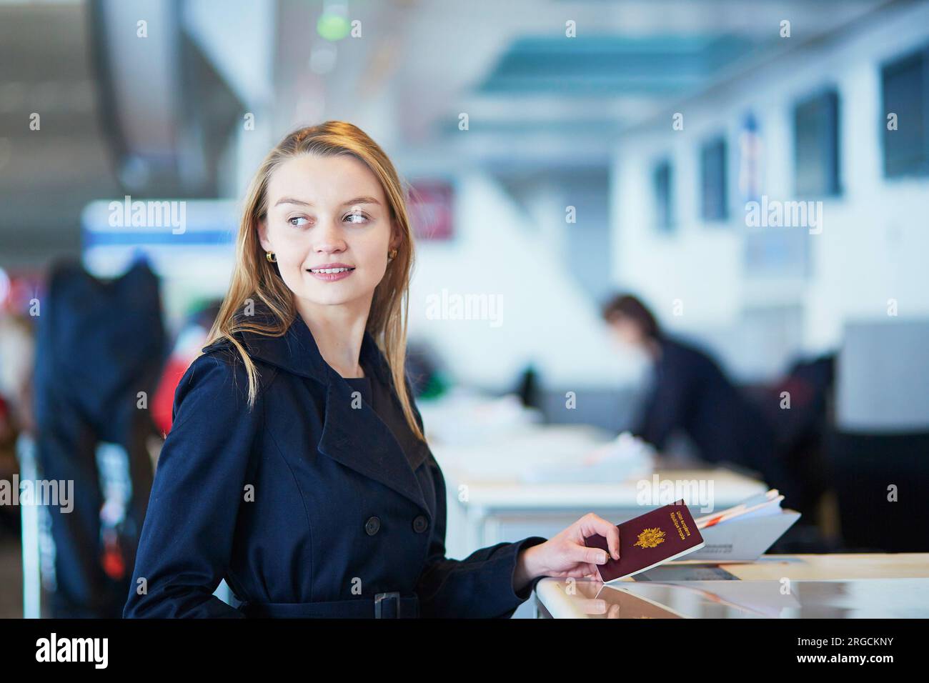 Young woman in international airport at check-in counter, giving her ...