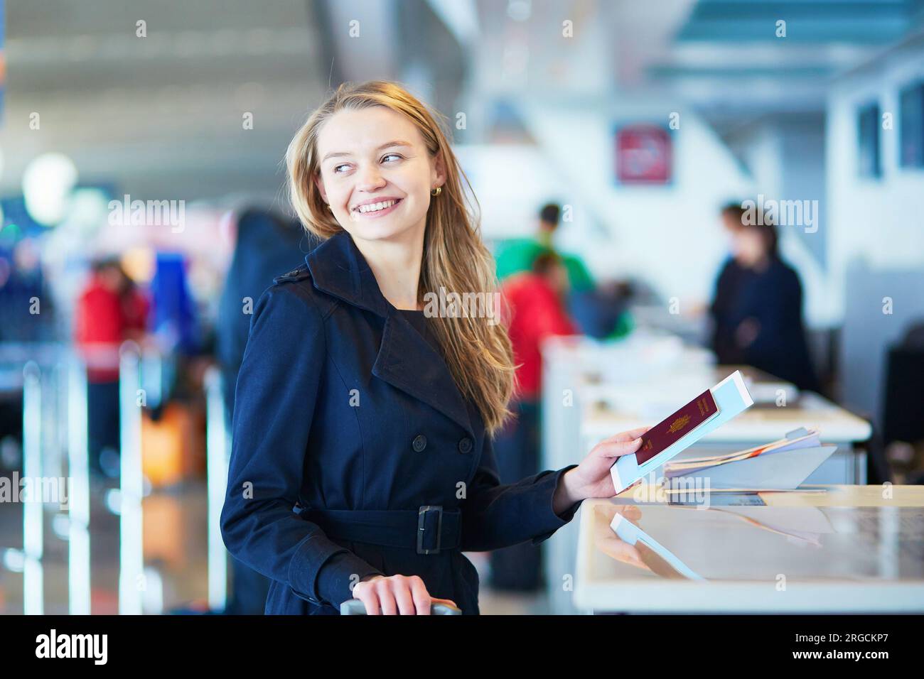 Young woman in international airport at check-in counter, giving her ...