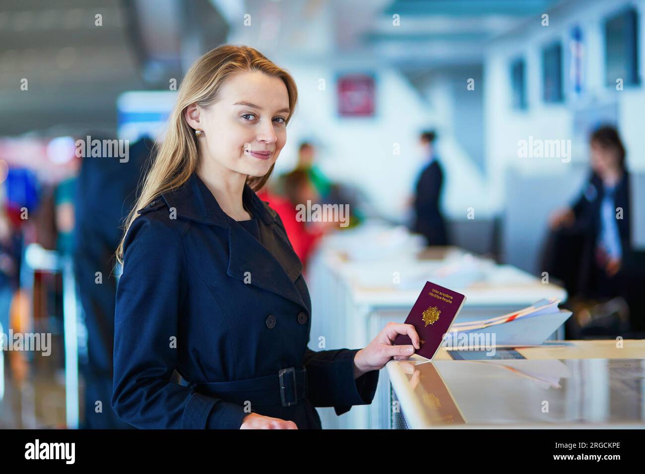Young woman in international airport at check-in counter, giving her ...
