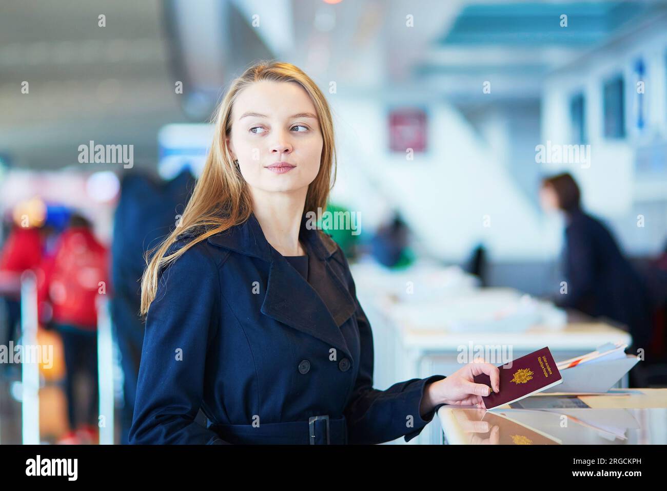 Young woman in international airport at check-in counter, giving her ...