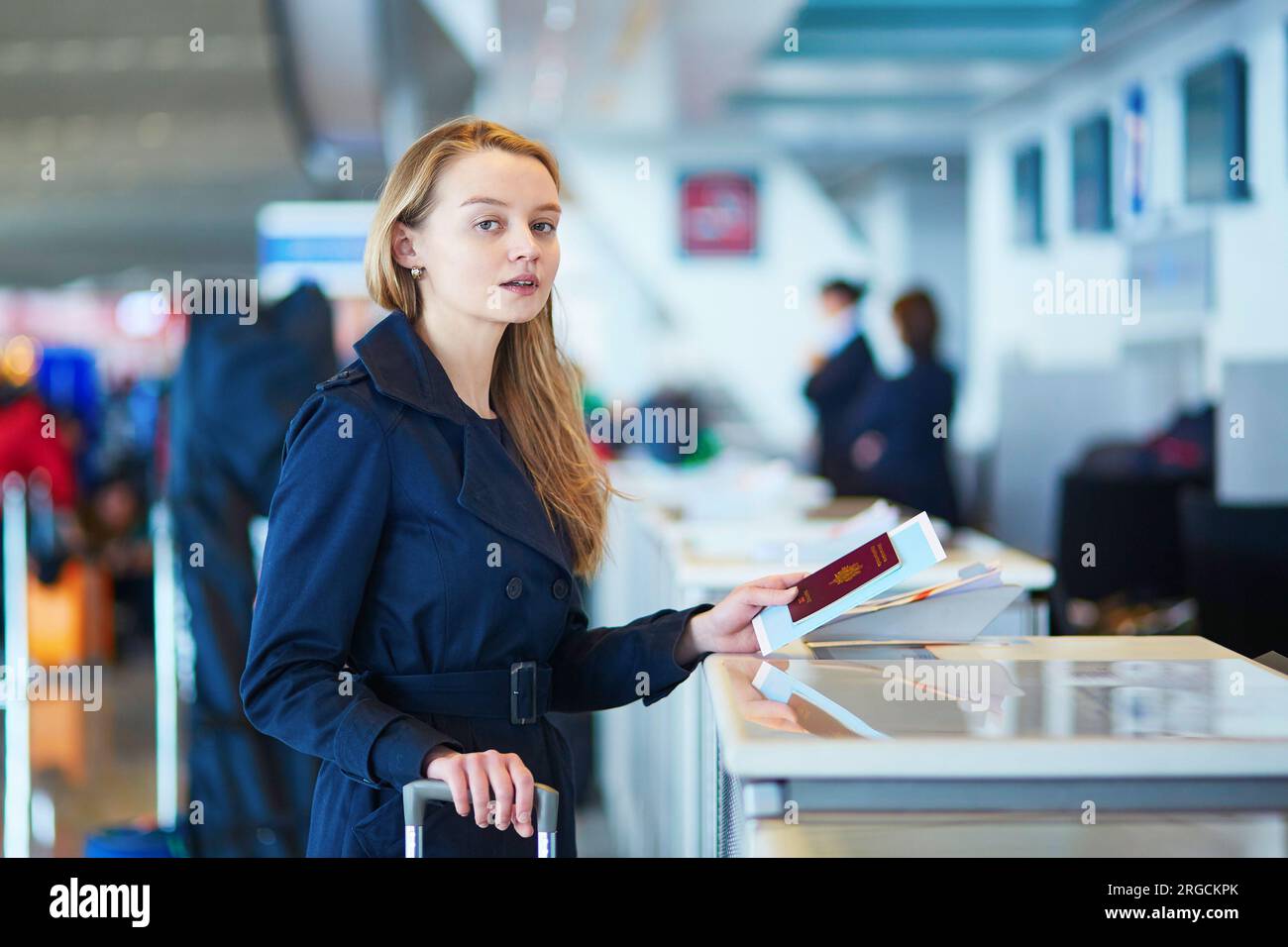Young woman in international airport at check-in counter, giving her ...