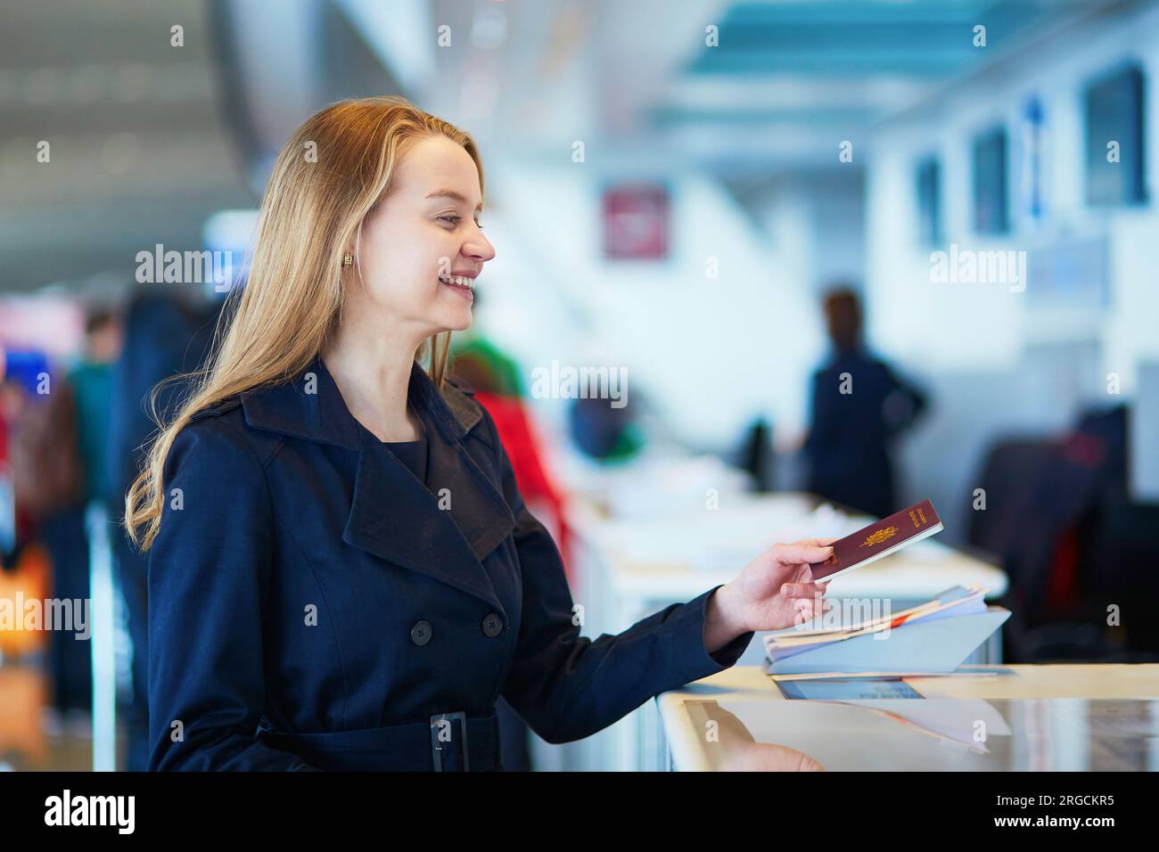 Young woman in international airport at check-in counter, giving her ...