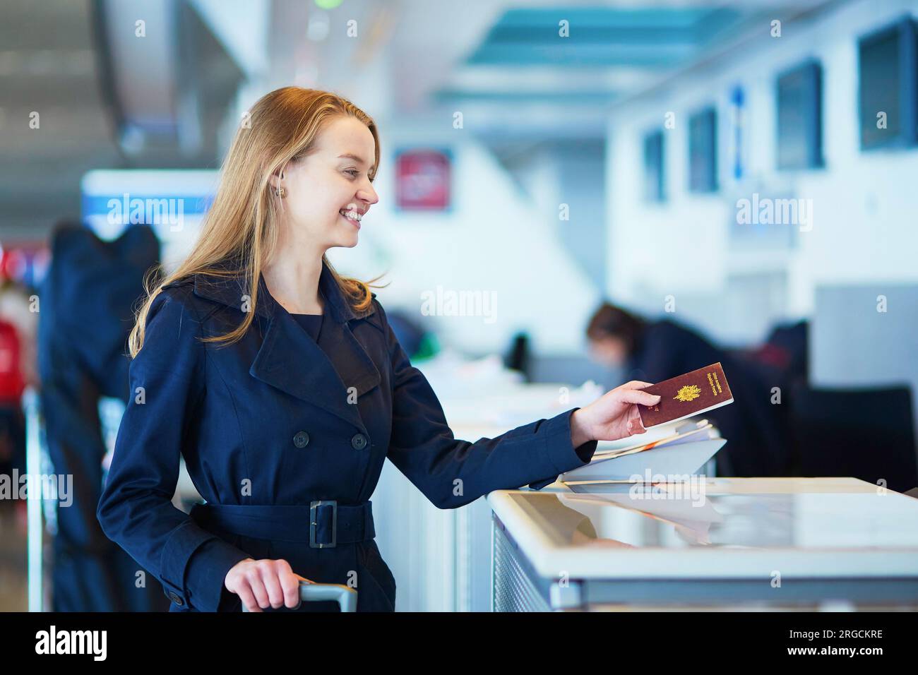 Young woman in international airport at check-in counter, giving her ...