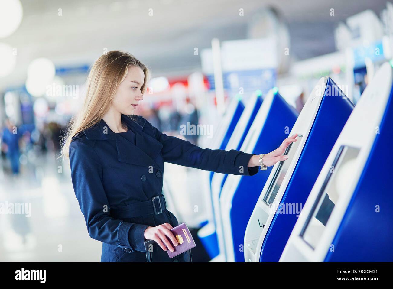 Young woman in international airport doing self check-in Stock Photo ...