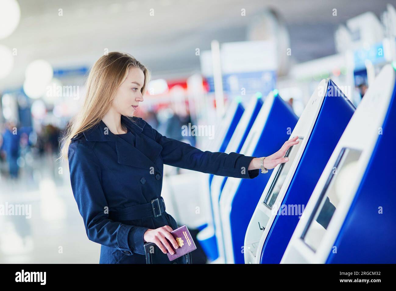 Young woman in international airport doing self check-in Stock Photo ...