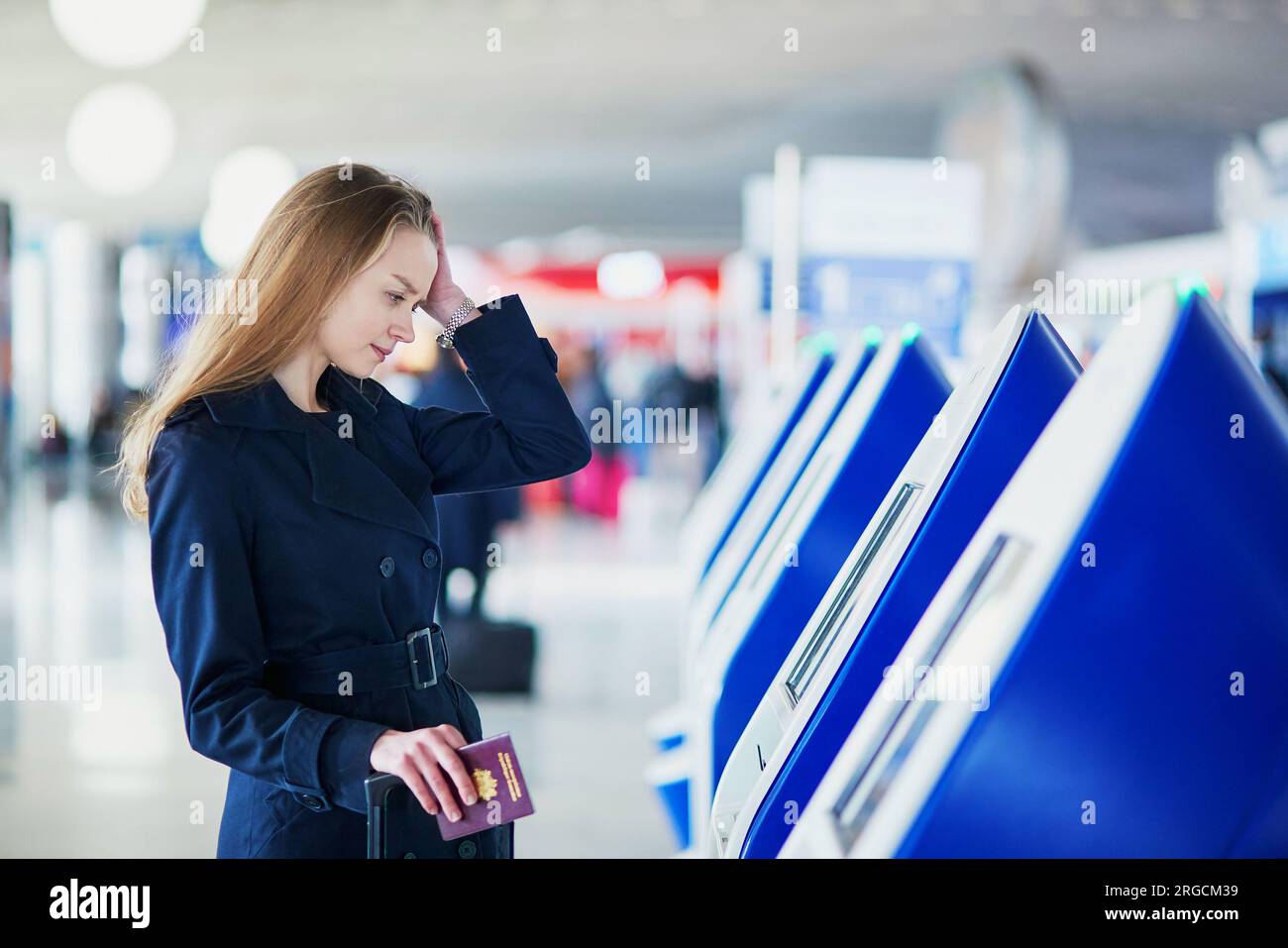Young woman in international airport doing self check-in, stressed and ...