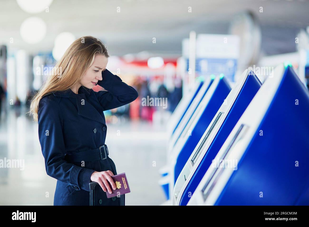 Young woman in international airport doing self check-in, stressed and ...