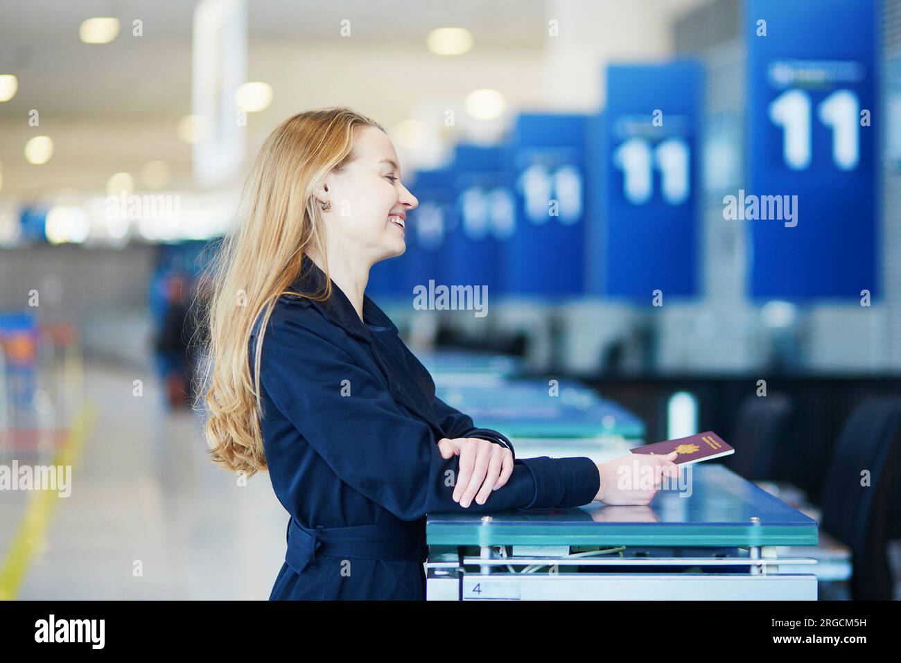 Young woman in international airport at check-in counter, giving her ...