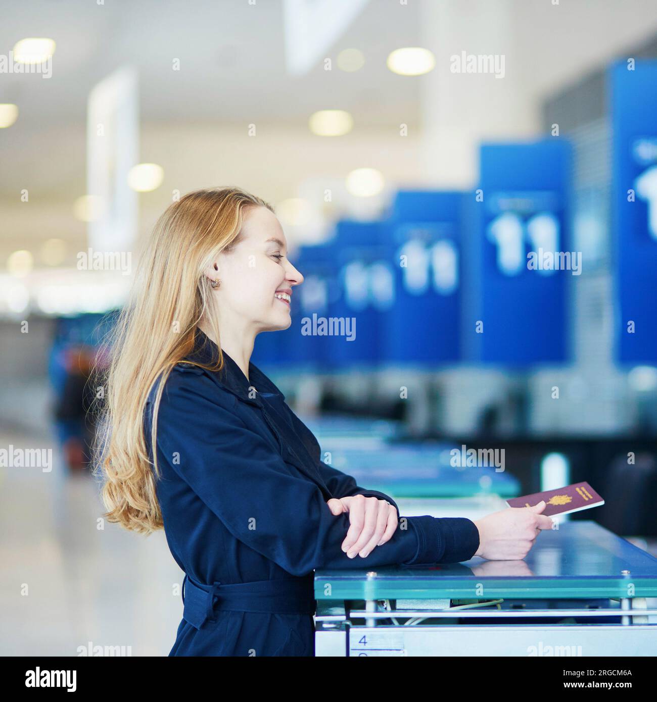 Young woman in international airport at check-in counter, giving her ...