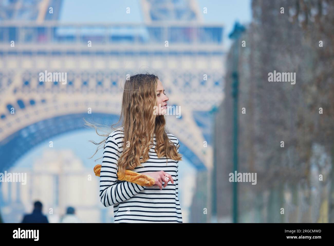 Beautiful young girl with fresh tasty traditional French bread ...