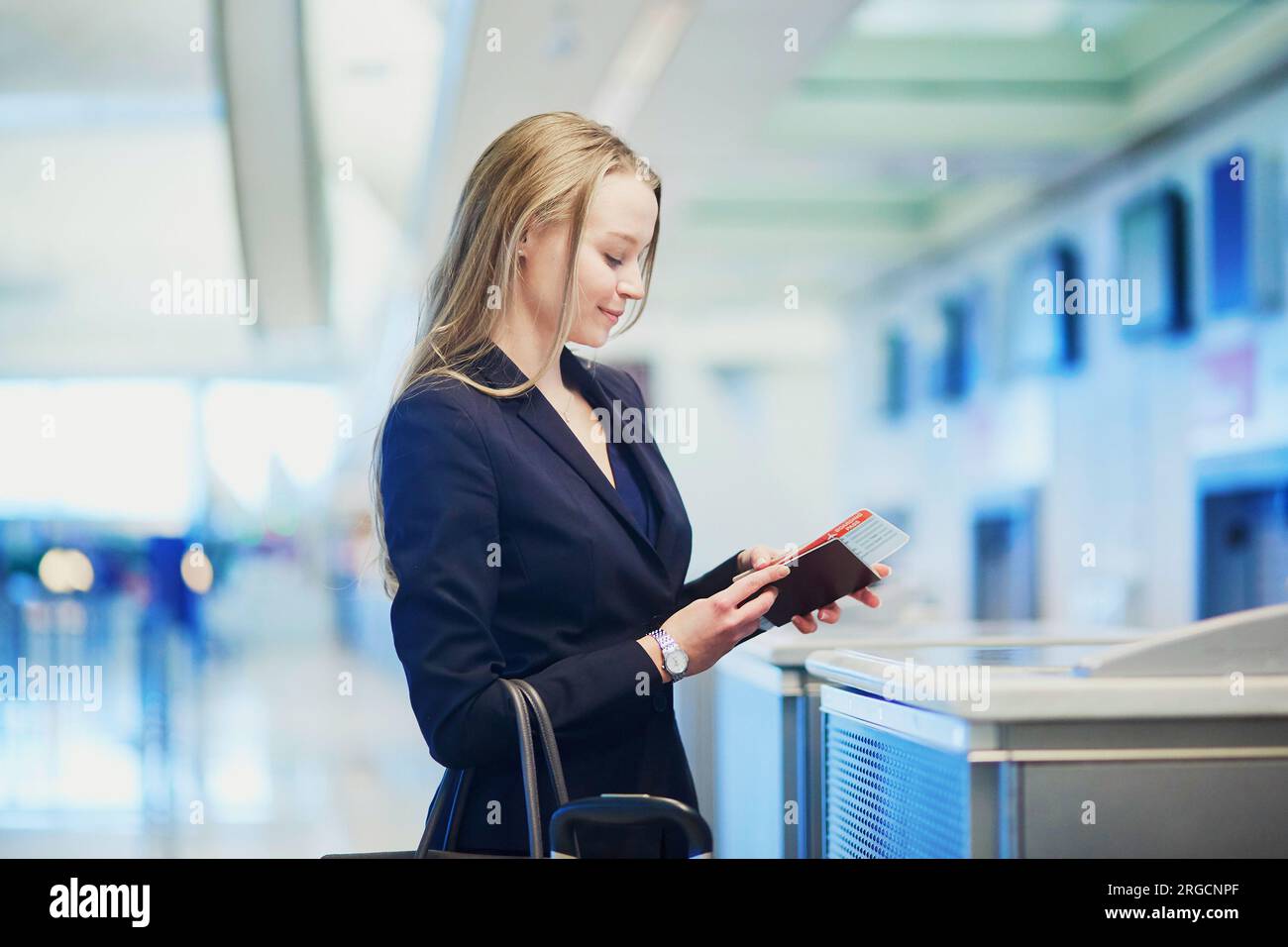 Young business woman in international airport at check-in counter ...