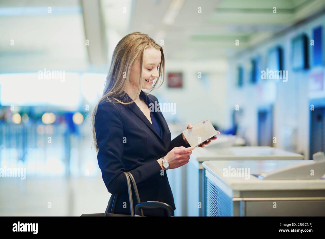 Young business woman in international airport at check-in counter ...