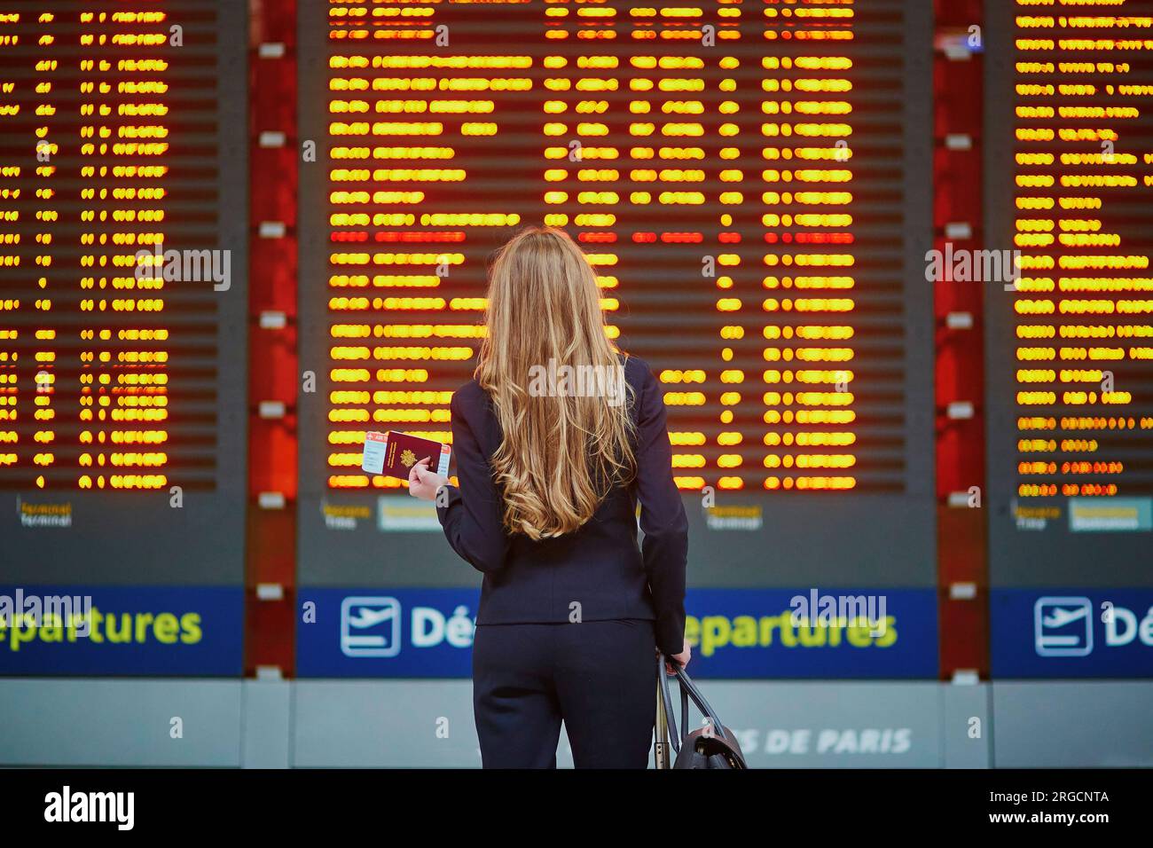 Young elegant business woman with hand luggage in international airport ...