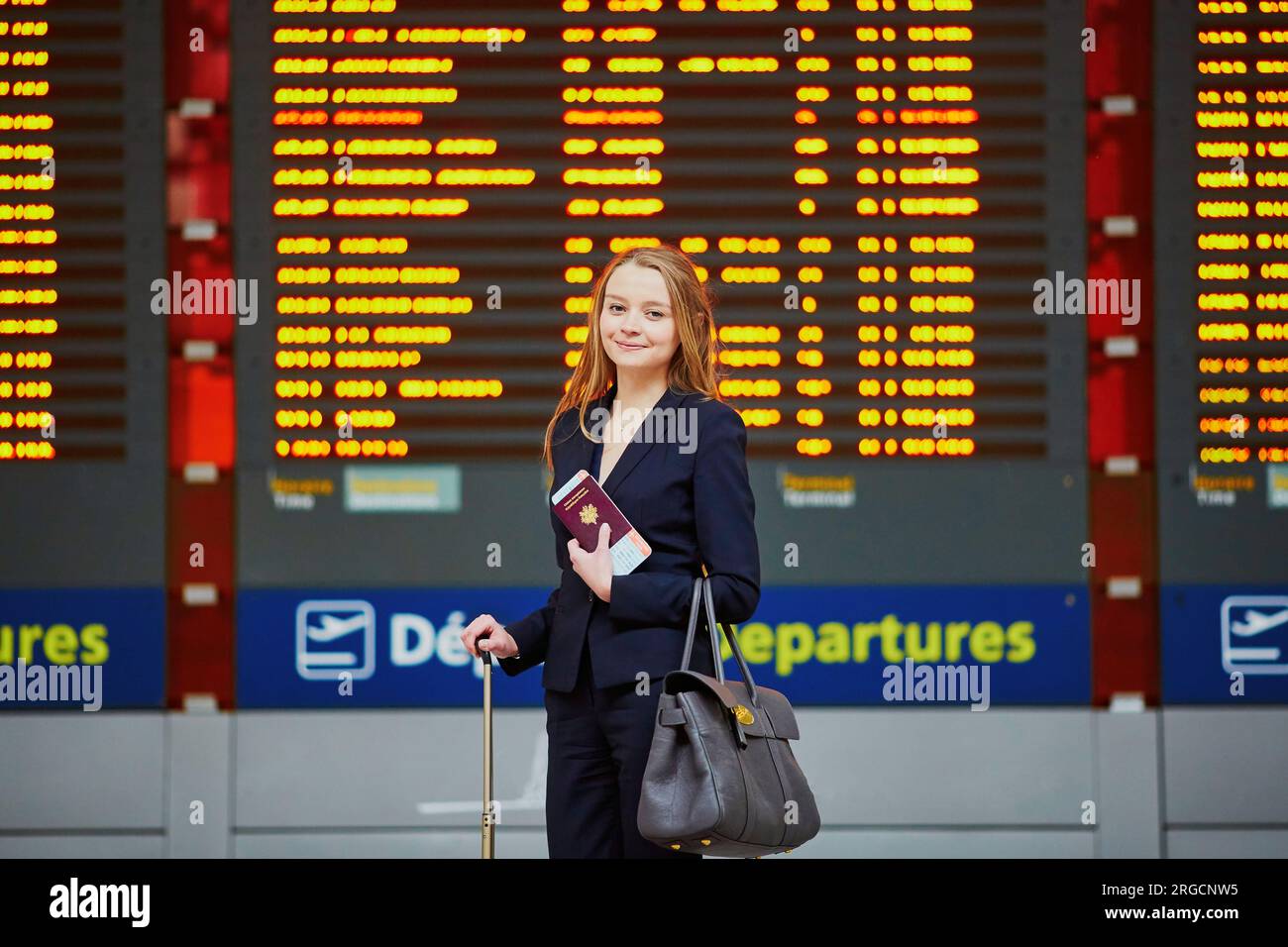 Young elegant business woman with hand luggage in international airport ...