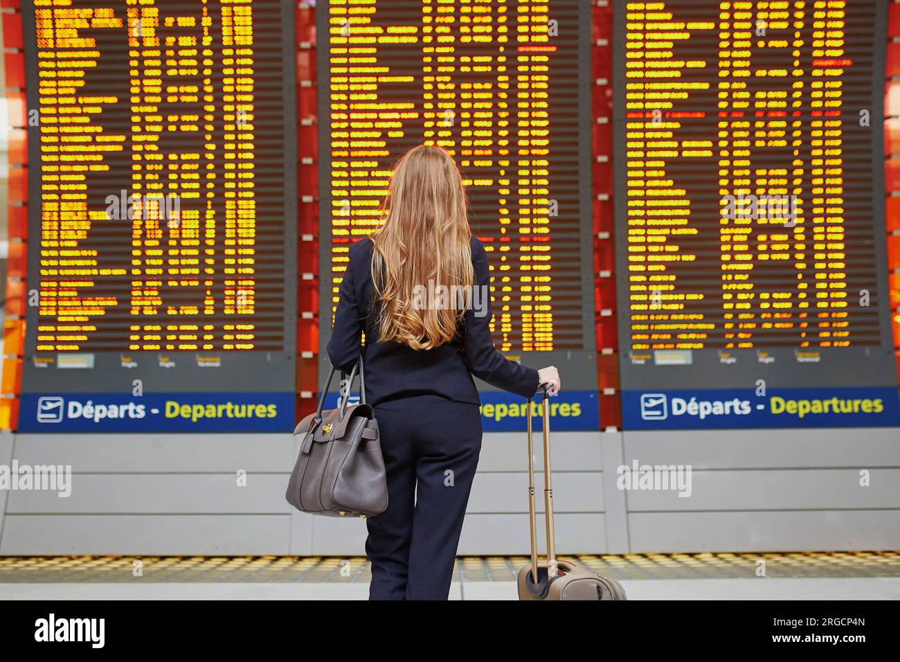 Young elegant business woman with hand luggage in international airport ...