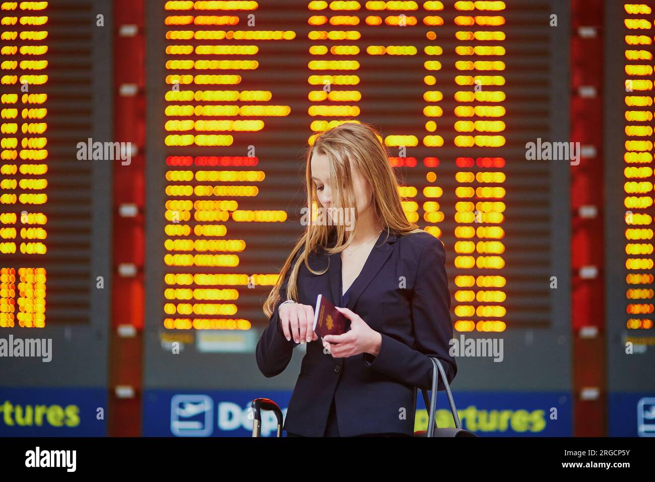 Young elegant business woman with hand luggage in international airport ...