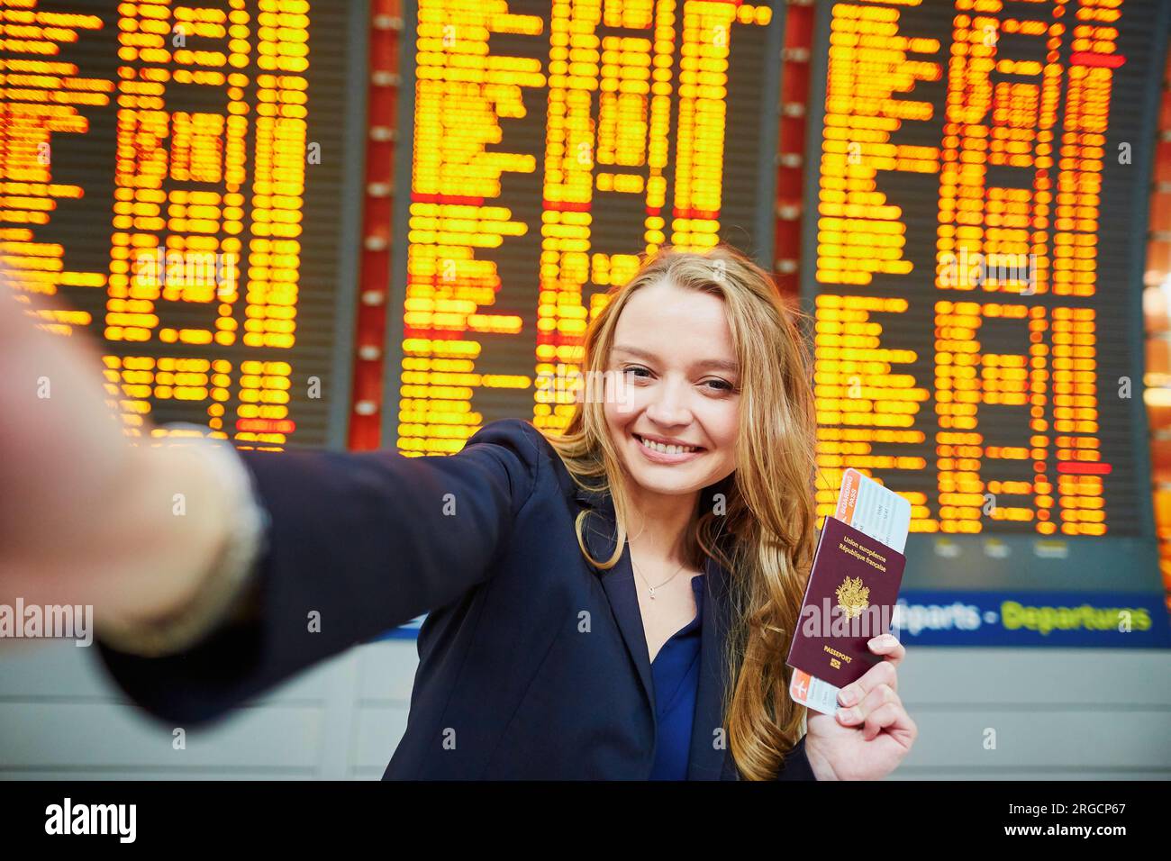 Happy young woman, holding French passport and boarding pass, doing ...