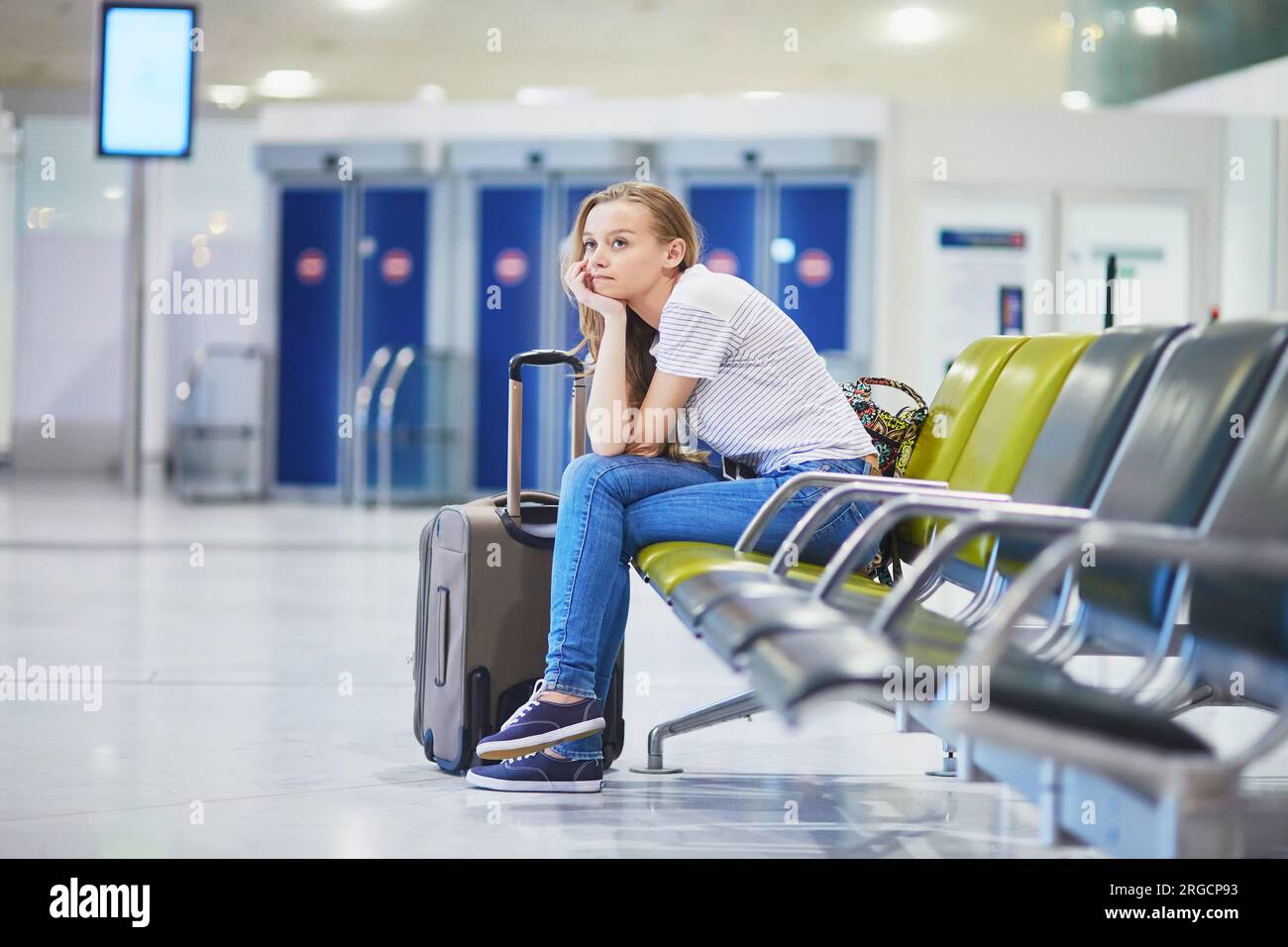 Young woman in international airport waiting for her flight Stock Photo ...