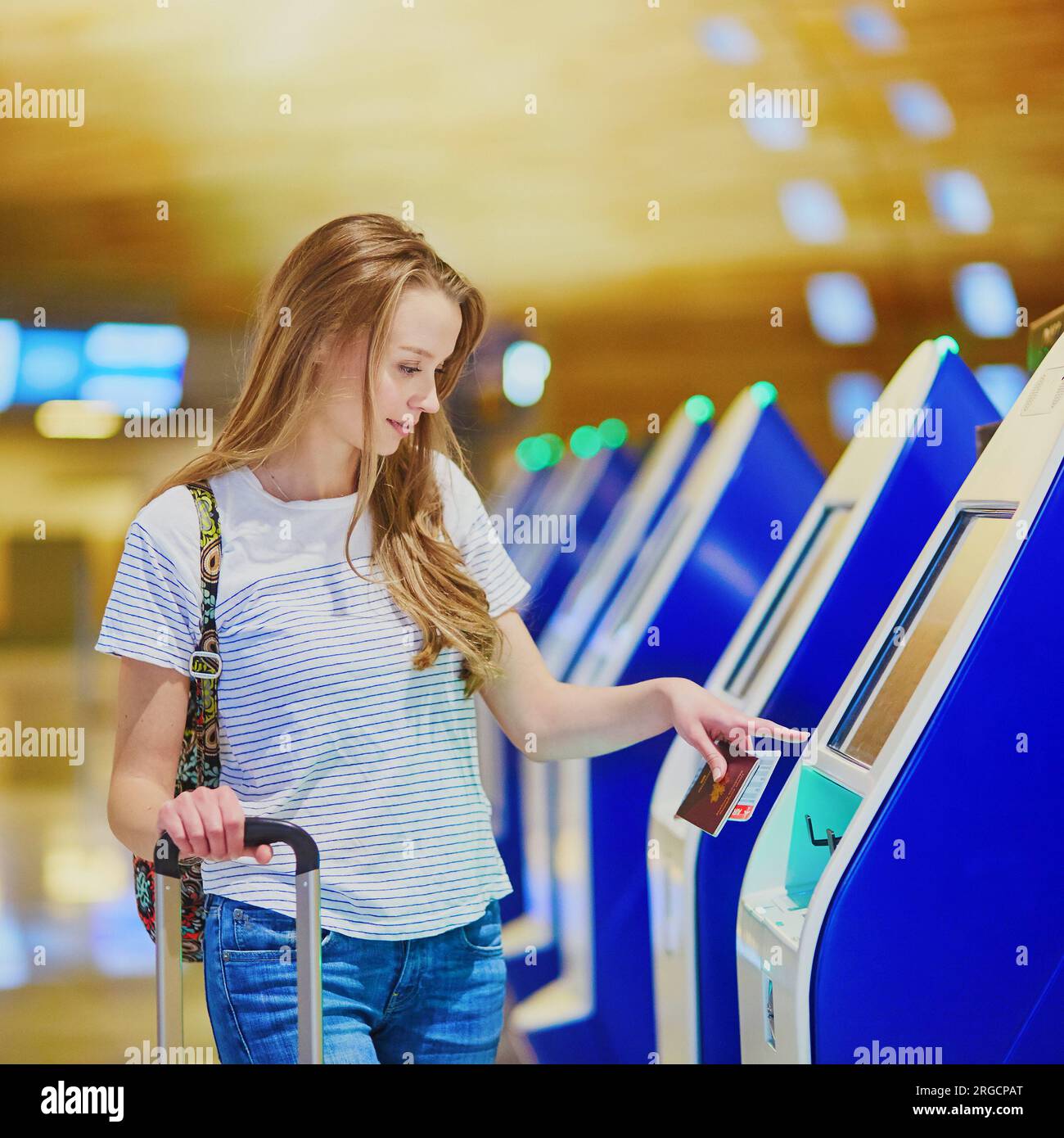 Young woman in international airport doing self check-in Stock Photo ...