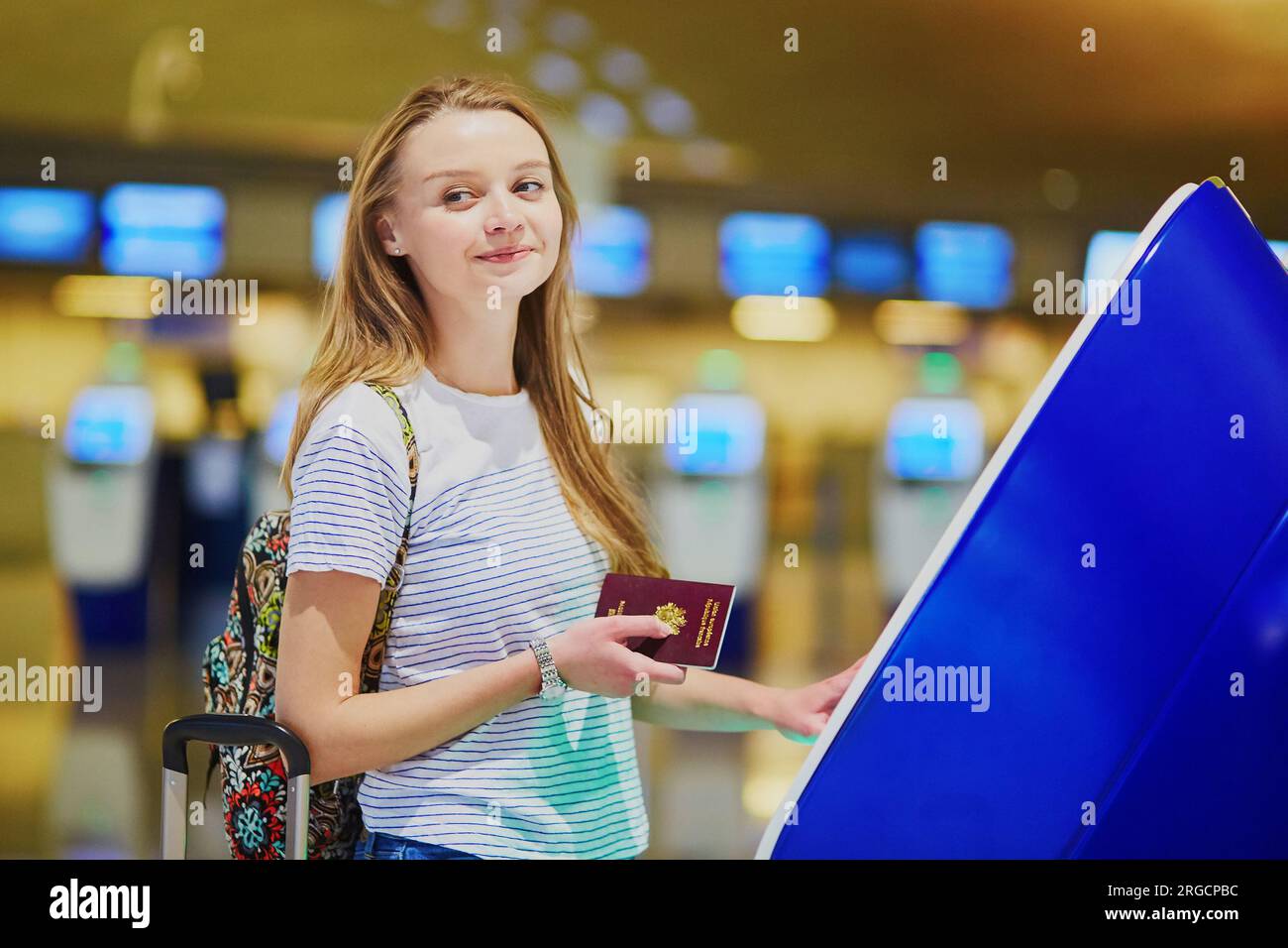 Young woman in international airport doing self check-in Stock Photo ...