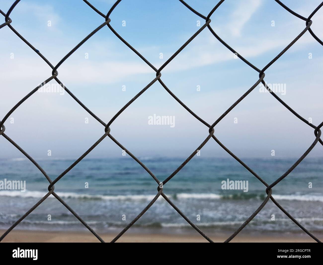 Protective mesh on beach background. Sea behind bars. Beach is closed ...