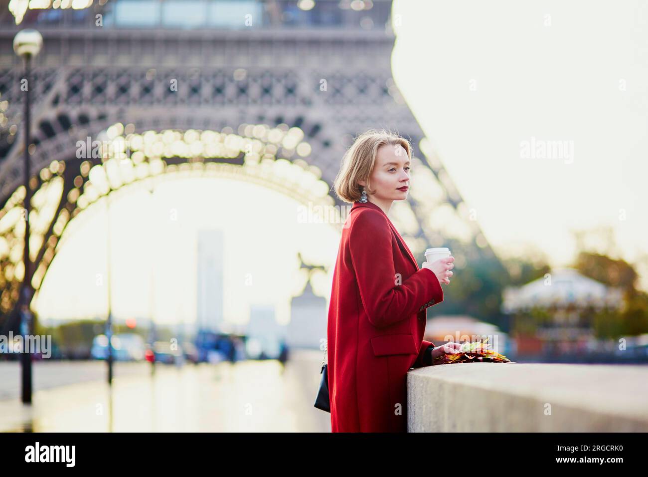 Beautiful young French woman drinking coffee near the Eiffel tower in ...