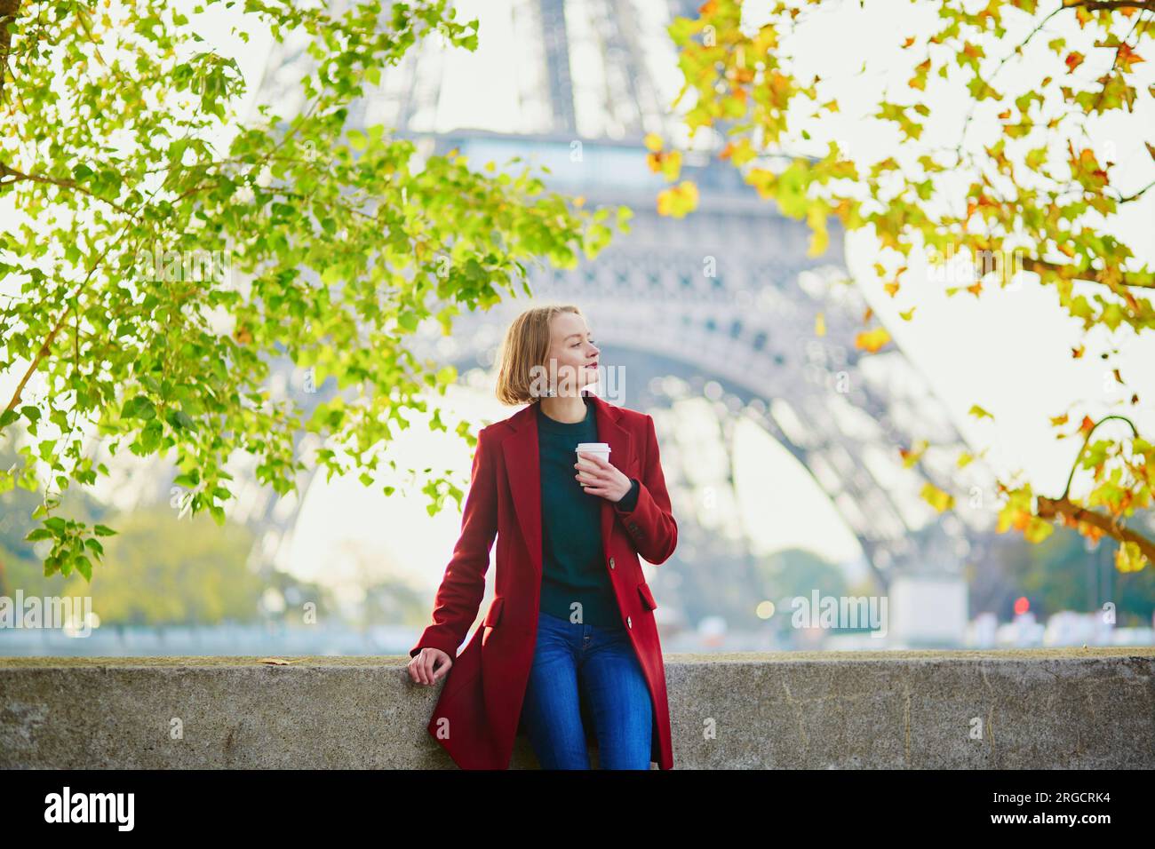 Beautiful young French woman drinking coffee near the Eiffel tower in ...