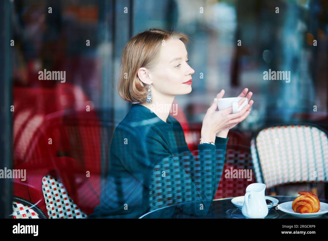Young elegant woman drinking coffee in traditional cafe in Paris ...