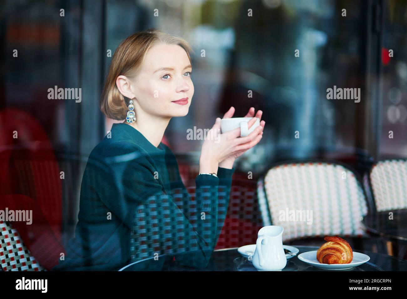 Young elegant woman drinking coffee in traditional cafe in Paris ...