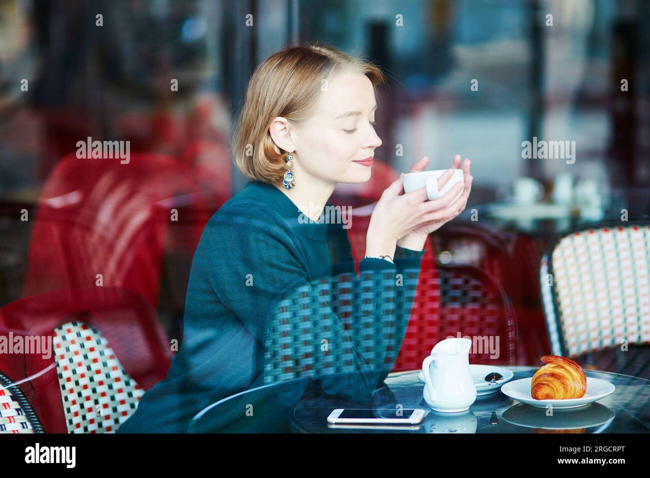 Young elegant woman drinking coffee in traditional cafe in Paris ...