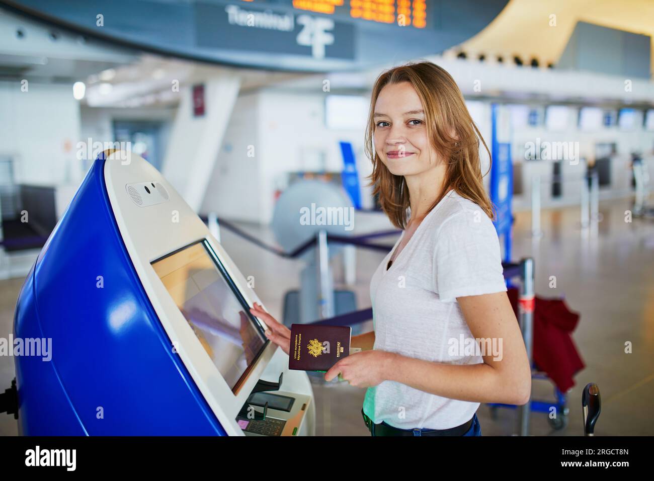Young woman in international airport doing self check-in Stock Photo ...