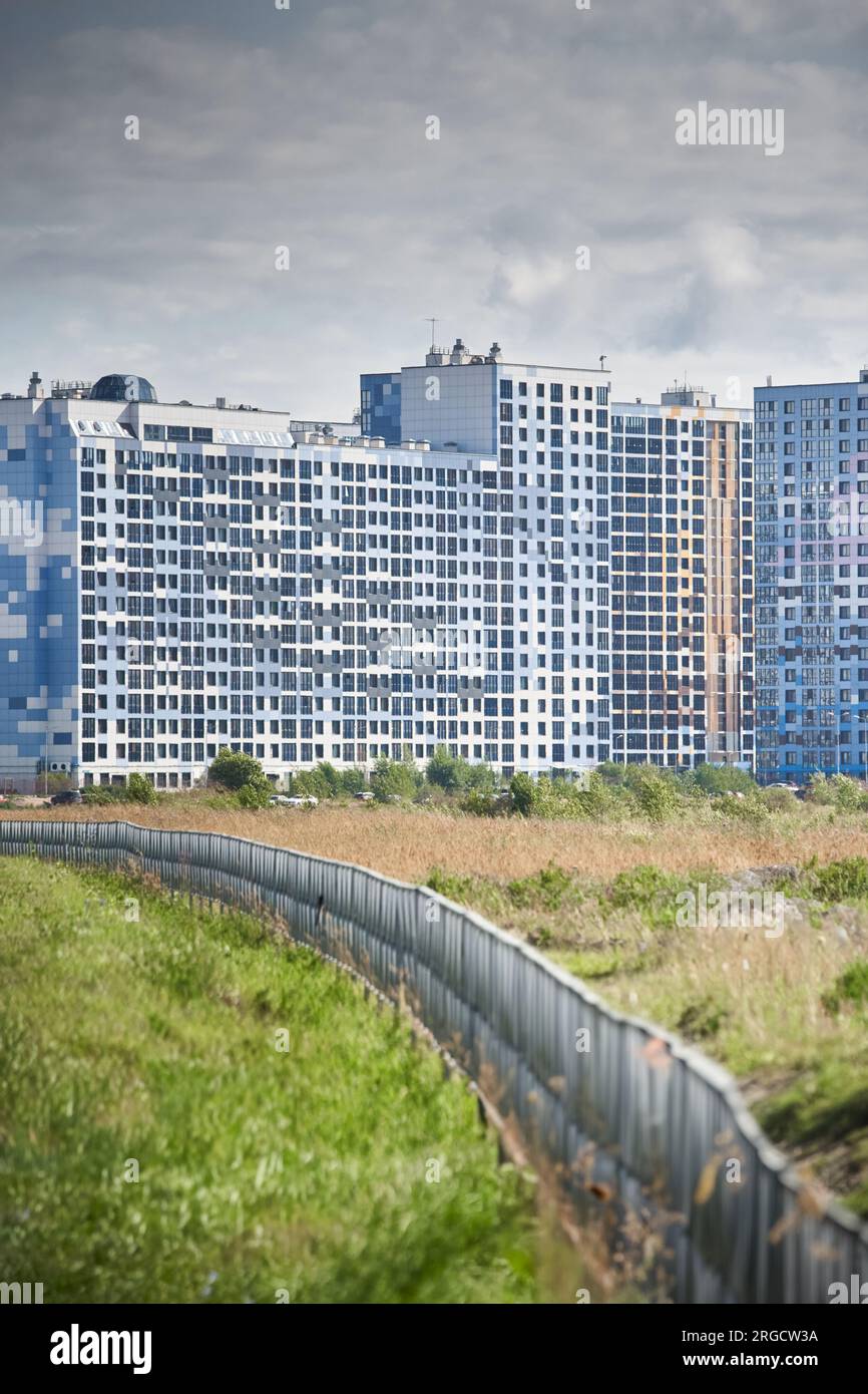 huge colorful residential complex in sunny weather, green vegetation in ...