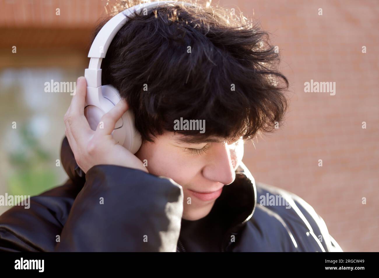 teenager listening to music with headphones outdoors without looking at ...