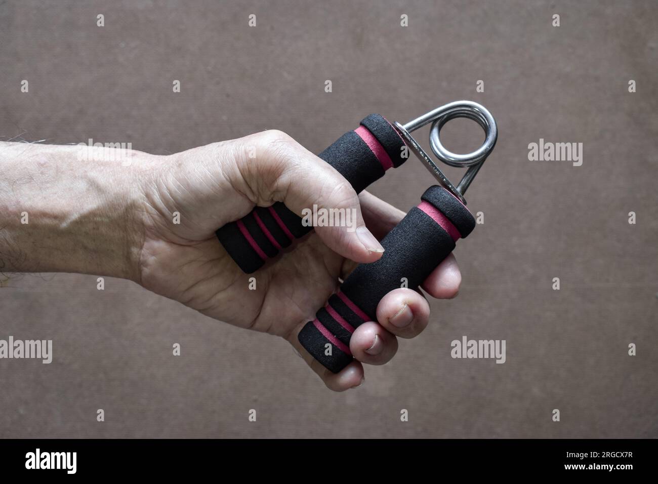 Hand of Southeast asian, Chinese old man gripping hand exercise gripper ...