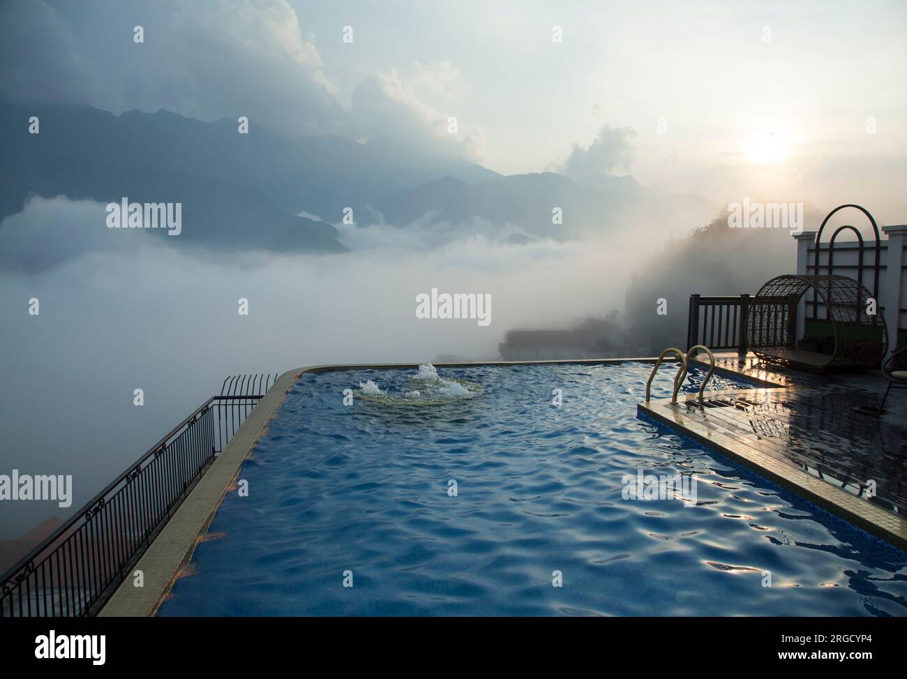 The scenic view of a cloudy sunset by the pool on a building rooftop in ...