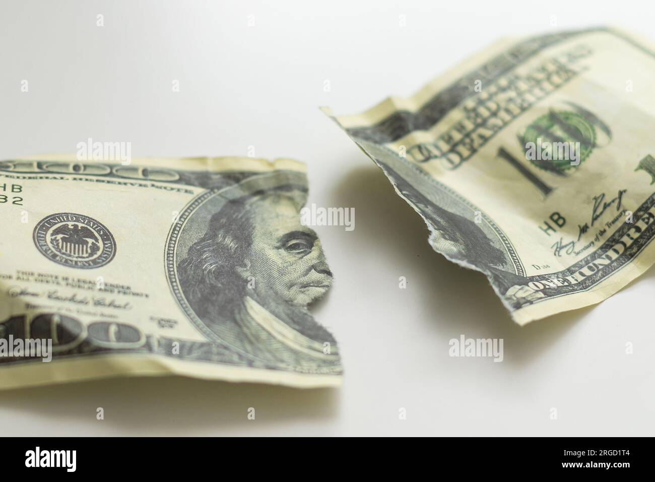 a hundred dollar bill torn in half on a white background top view Stock ...