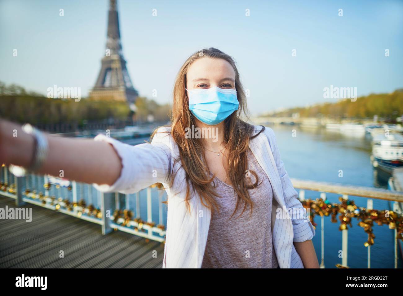 Girl near Eiffel tower in Paris wearing mask and taking selfie or ...