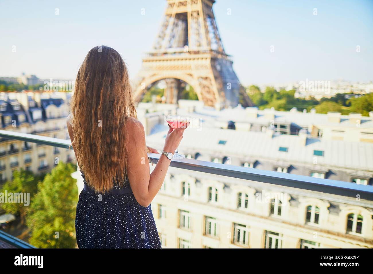 Beautiful young woman drinking alcoholic cocktail in a rooftop ...