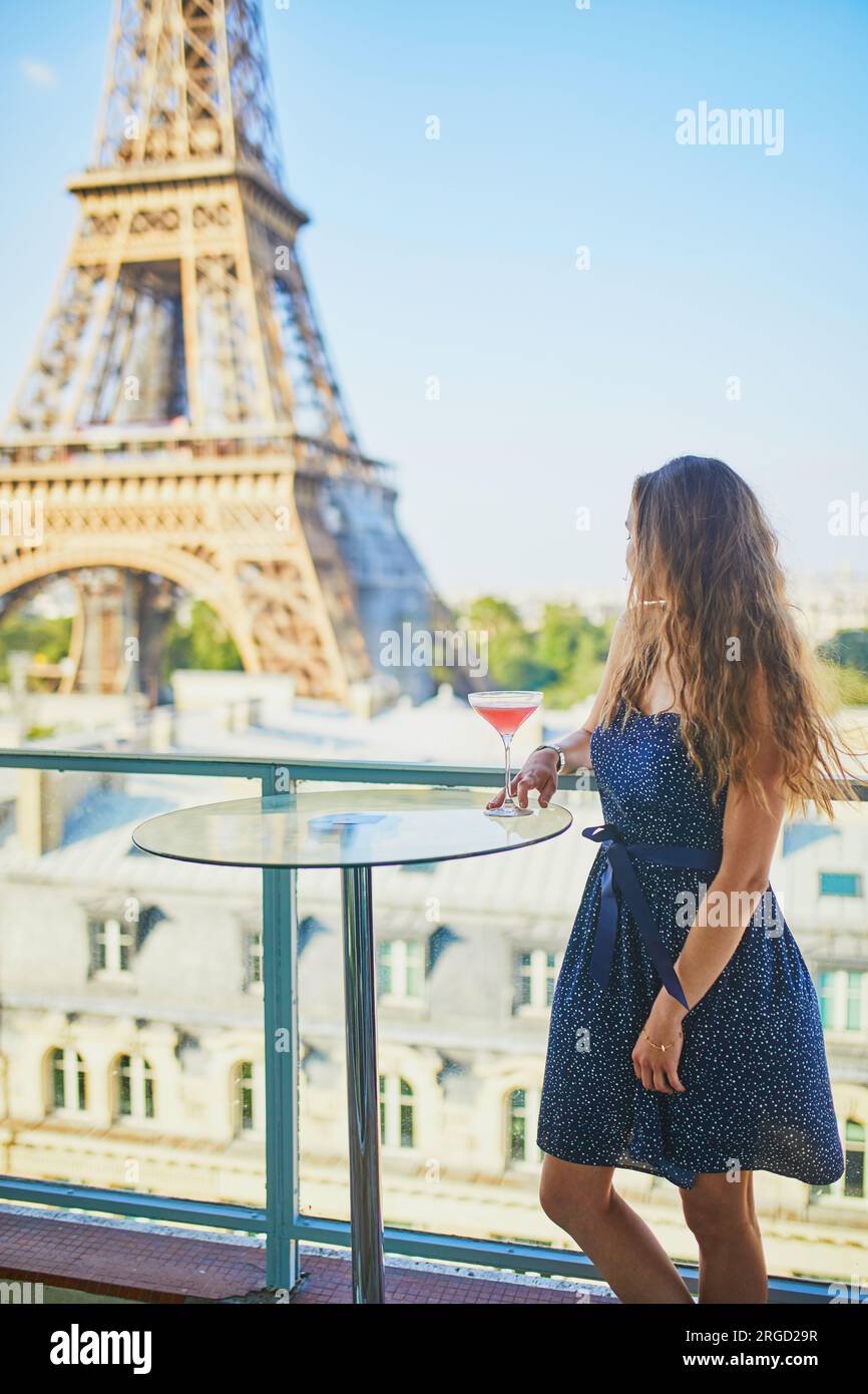 Beautiful young woman drinking alcoholic cocktail in a rooftop ...