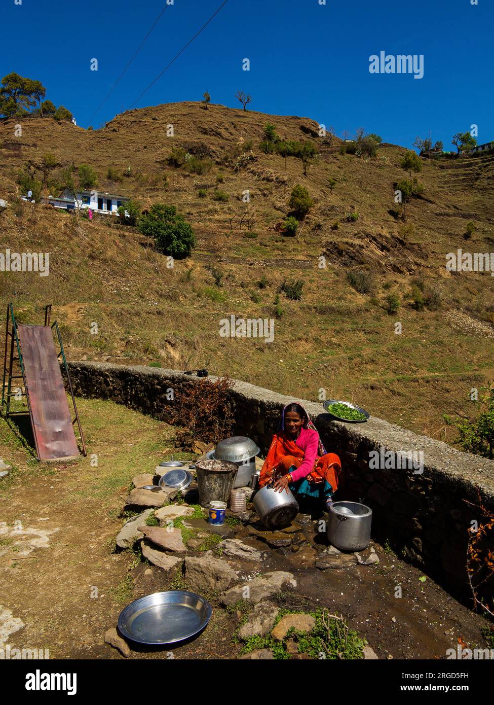 Indian woman washing pans near his house at the outskirts of Lamgara ...