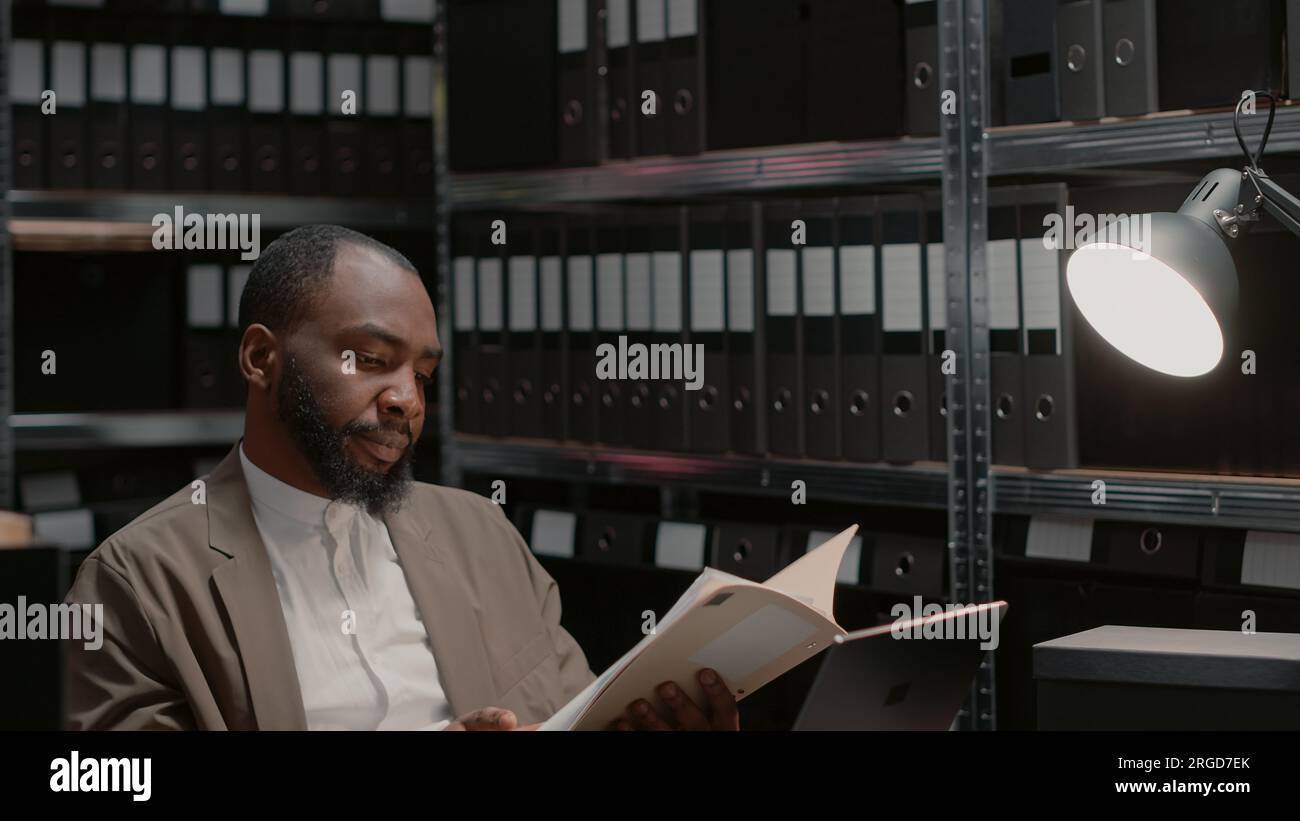 Law officer examining physical evidence in case files, using criminal ...