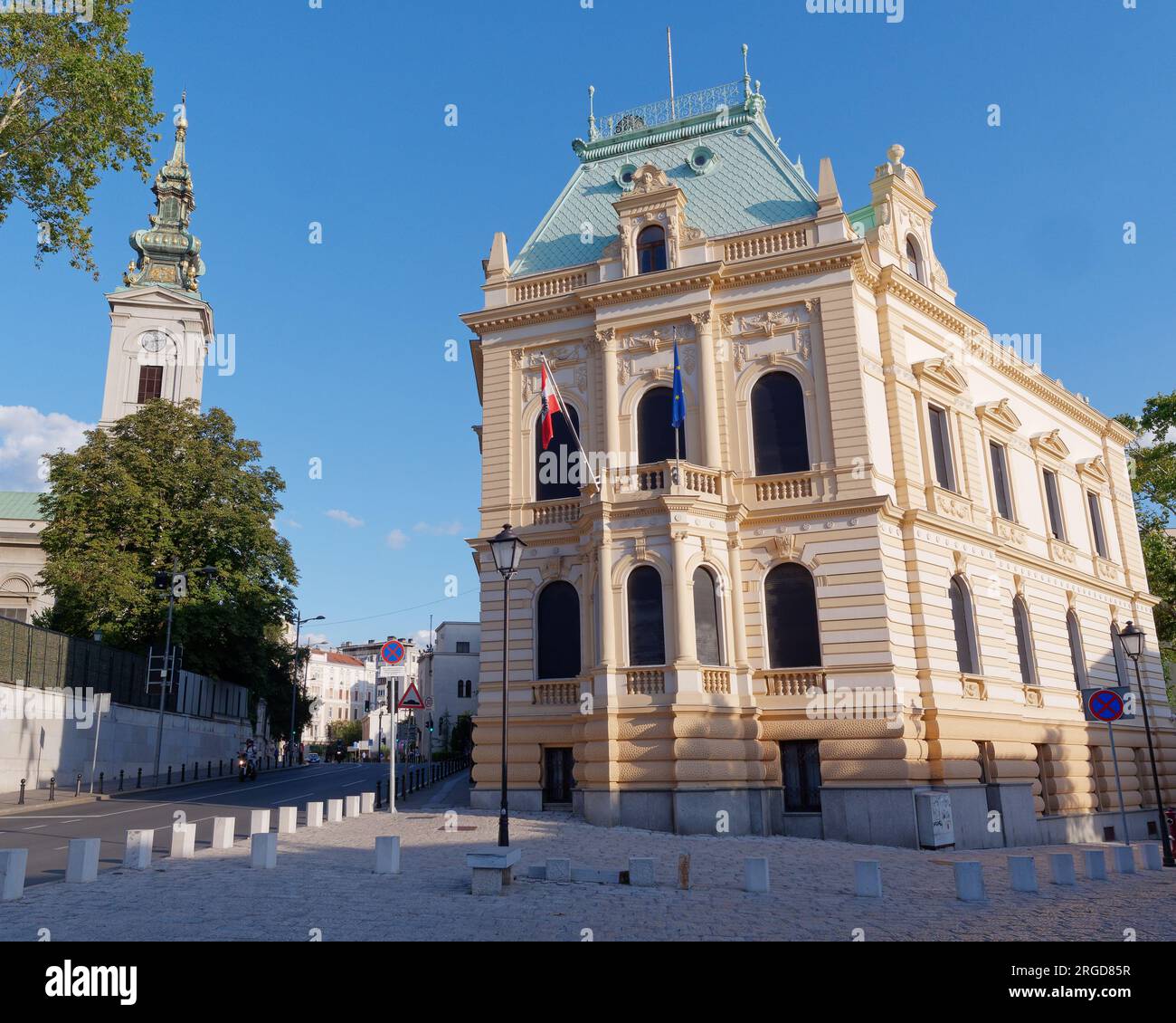 Elegant corner building opposite a church with green roof in the city ...